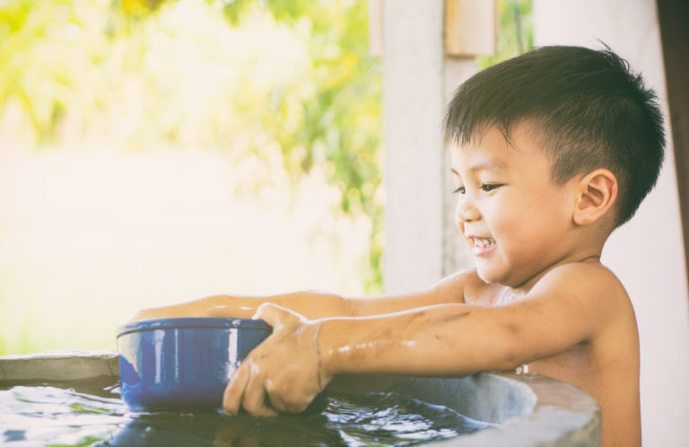 Asian Village poor boy is taking a bath from village water well ...